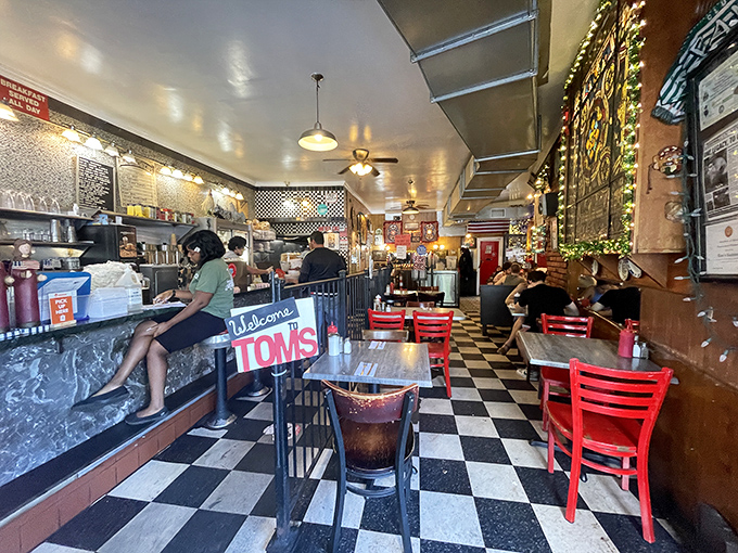 Red chairs pop against the checkered floor like exclamation points in a diner conversation. This isn't decoration—it's punctuation.