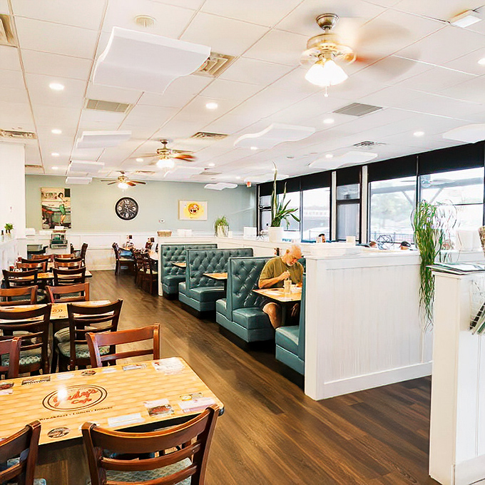 Teal booths invite lingering conversations while a solo diner enjoys the peaceful rhythm of a meal without rushing &ndash; the true luxury of a neighborhood cafe.