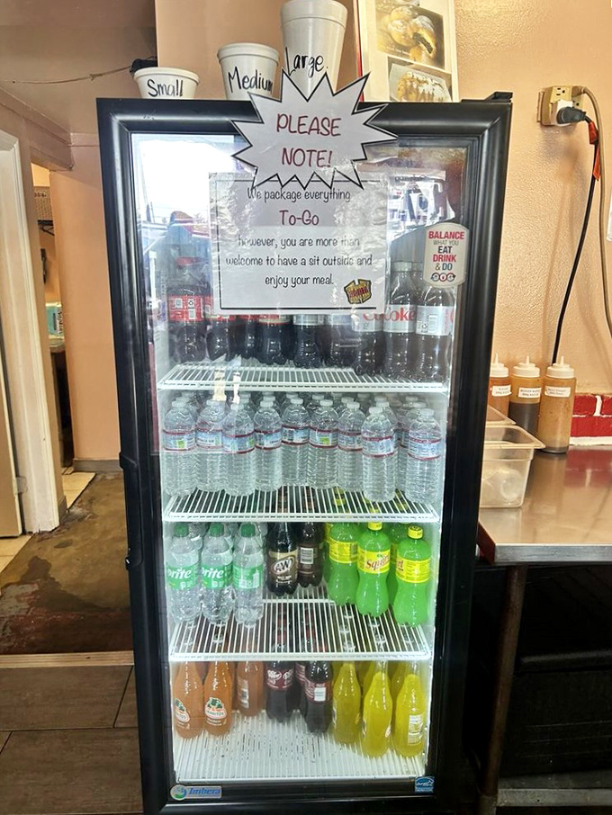 The drink fridge offers a welcome respite from the flavor intensity. Note the charming "sit outside and enjoy your meal" invitation.
