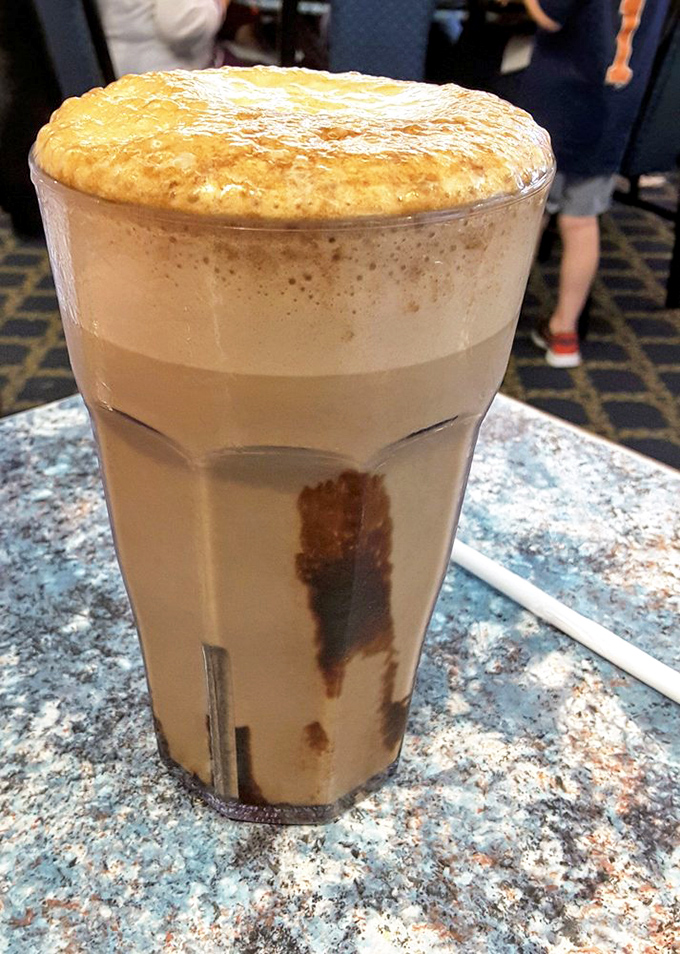 The egg cream rises majestically in its glass &ndash; a frothy delight that defies its name by containing neither egg nor cream.