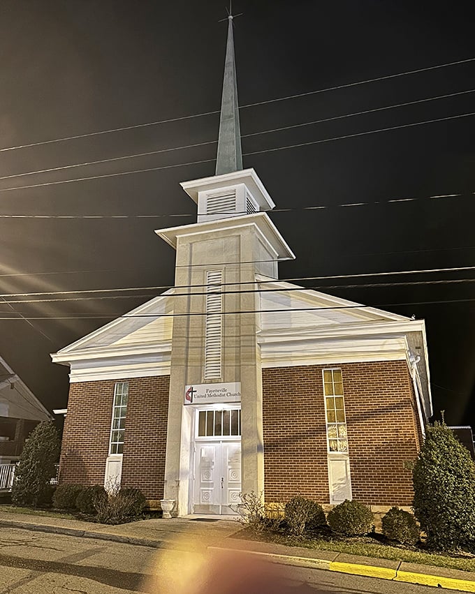 Fayetteville United Methodist Church's steeple pierces the night sky, a beacon of faith that's been guiding the community for generations.