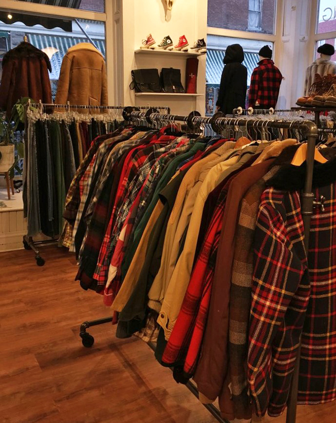 The flannel motherlode! Every shade of plaid imaginable hangs in perfect formation, like a lumberjack's dream closet or a 90s grunge band's wardrobe department.
