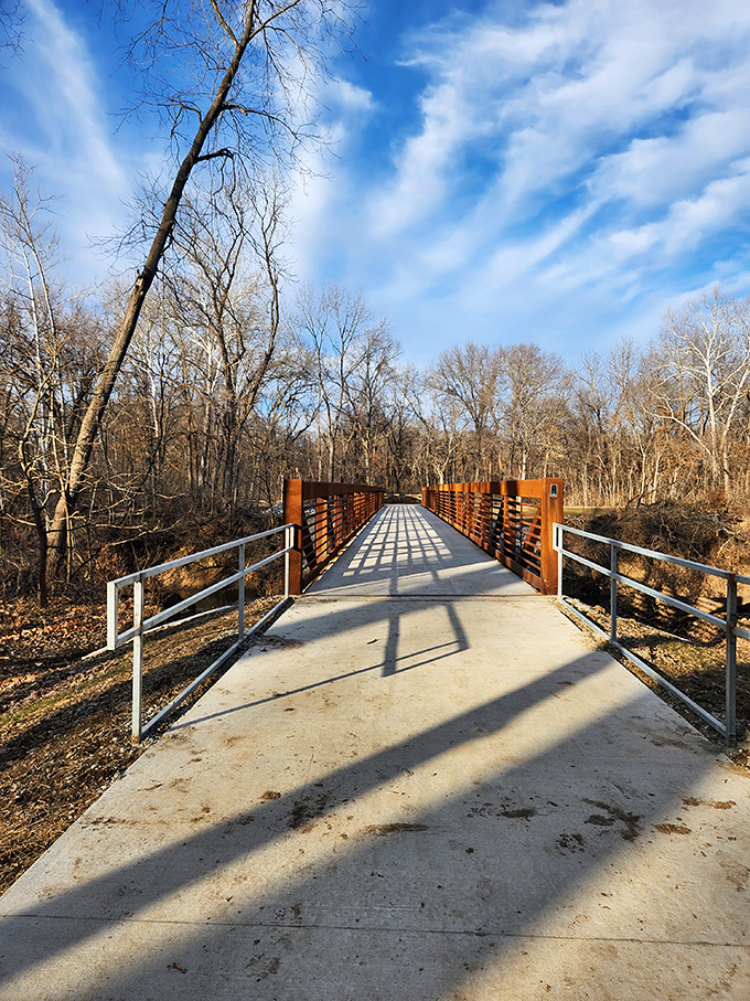 This footbridge isn't just crossing a stream &ndash; it's the gateway to adventure, beckoning visitors with geometric precision amid wild beauty.