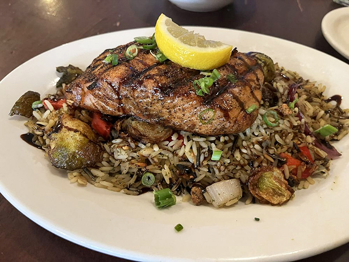 Salmon perched atop a bed of rice like royalty on a throne, with a crown of green onions and the perfect char marks of honor.