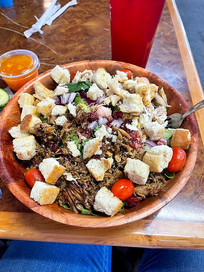 A wooden bowl showcasing the "salad loophole" – where pulled pork and croutons technically count as a balanced meal if served over greens.