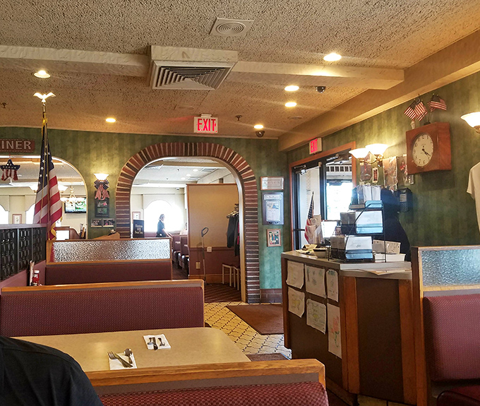 Brick archways frame the dining areas, creating cozy nooks for conversation. The American flag stands proudly—this is diner patriotism at its finest.