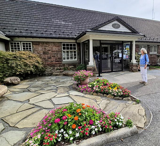 Stone pathways and vibrant flowers create an entrance that says "welcome" better than any doormat. Nature and architecture in perfect harmony. 