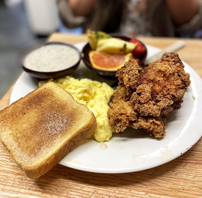 Comfort on a plate: golden fried chicken, scrambled eggs, and toast&mdash;the breakfast equivalent of a warm hug from your favorite aunt.
