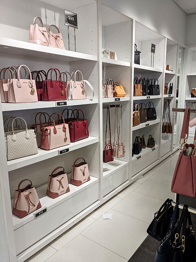A wall of Michael Kors handbags that whispers "luxury" while the price tags shout "accessible" &ndash; the perfect retail harmony.