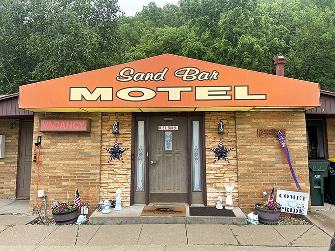 The Sand Bar Motel's cheerful facade welcomes weary travelers. No infinity pools here, just infinite Midwestern hospitality and river views.