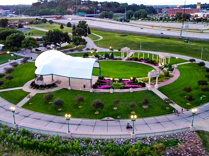 The Grandview Park Bandshell sits like a pristine white seashell amid a sea of green, hosting summer concerts where music and sunsets create perfect memories.