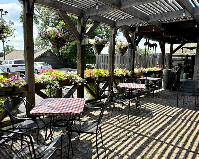 The outdoor patio offers a perfect summer escape, where checkered tablecloths and hanging flowers create an atmosphere that screams "linger longer."