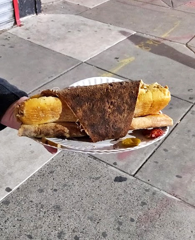 The ultimate Philadelphia power couple&mdash;a mammoth pizza slice cozying up to a cheesesteak on a paper plate, sidewalk dining at its most gloriously unapologetic.