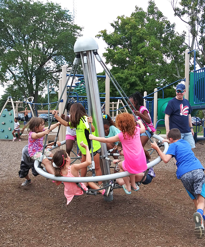 Children finding joy in simple playground physics&mdash;a reminder that Youngstown offers its youngest citizens spaces to play, learn, and grow together.