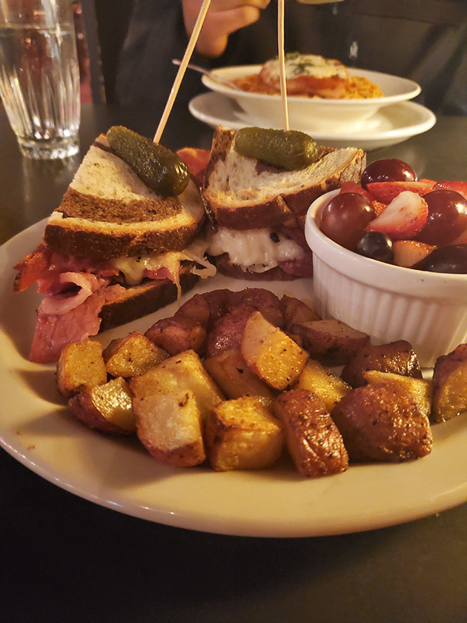 The Reuben sandwich in its natural habitat &ndash; surrounded by crispy potatoes and fresh fruit. A deli classic elevated to fine dining status.