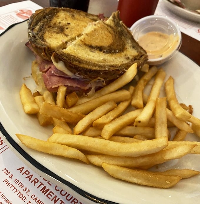 The Reuben sandwich, served with a mountain of fries. When a sandwich requires both hands and a strategy, you know you're in for something good.