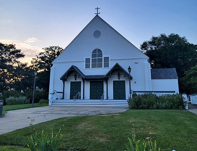 Saint Andrew Roman Catholic Church's white clapboard simplicity against the sunset sky is New England spirituality in architectural form.