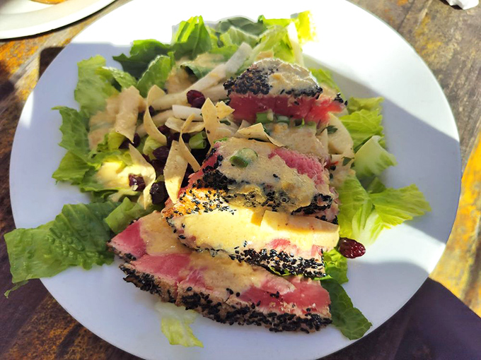 Seared tuna salad with a sesame crust that's both art and appetite satisfaction. The rare center tells a tale of culinary precision.