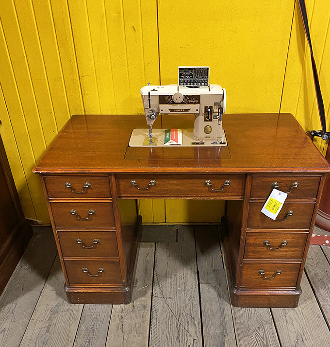 A vintage sewing machine on its wooden desk, ready to stitch together your grandmother's wildest crafting dreams once more.