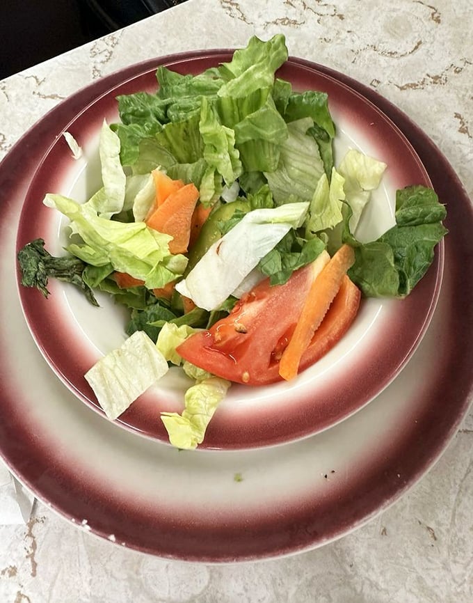 Even the side salad gets the respect it deserves. Crisp, fresh, and served on those iconic burgundy-rimmed plates.