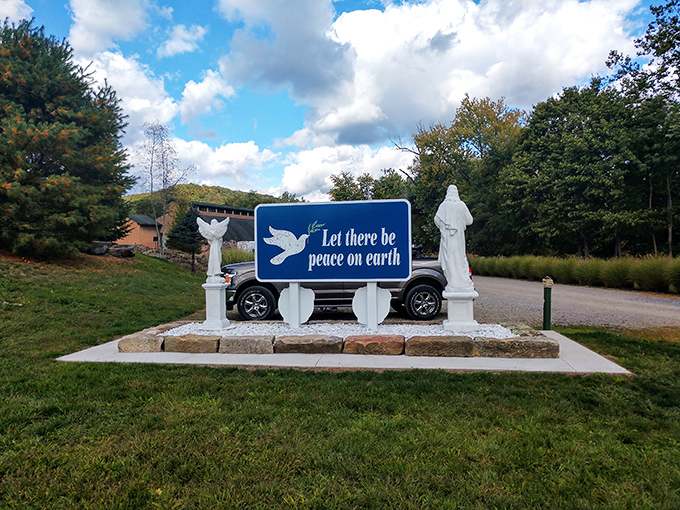 "Let there be peace on earth" reads the sign, flanked by statues in a serene corner that feels worlds away from everyday worries.