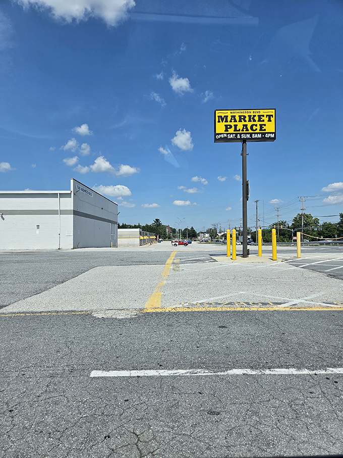 Against Maryland's blue sky, the marketplace sign stands tall like a yellow beacon of bargain-hunting hope. Weekend warriors, your destination awaits.