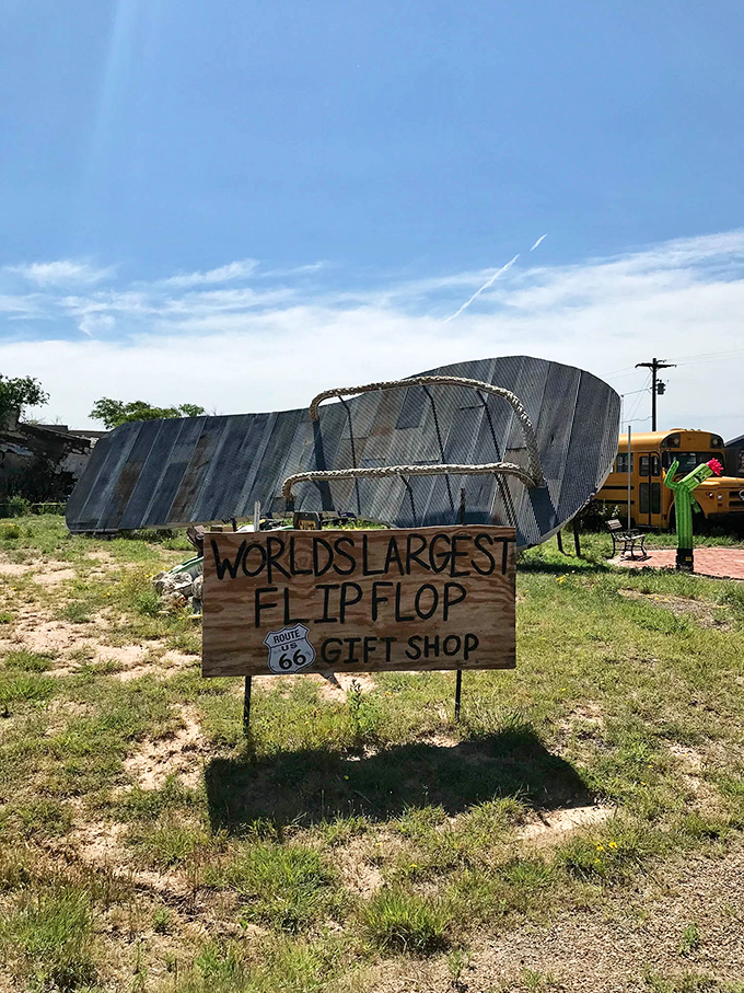 The handcrafted wooden sign proudly announces your arrival at roadside Americana perfection, where Route 66 heritage meets monumental beach attire.