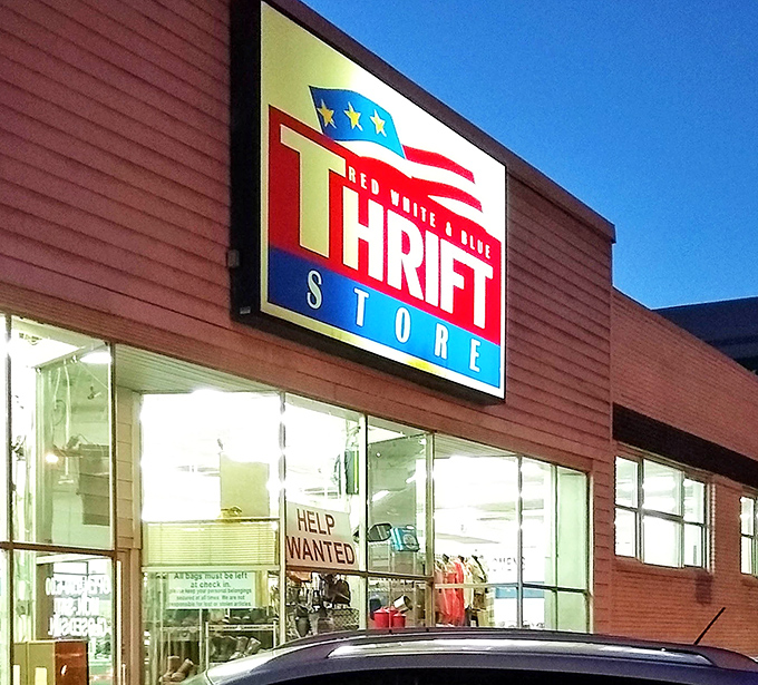 The illuminated sign glows like a North Star for the budget-conscious shopper. Even at night, the hunt for treasures continues under those patriotic colors.