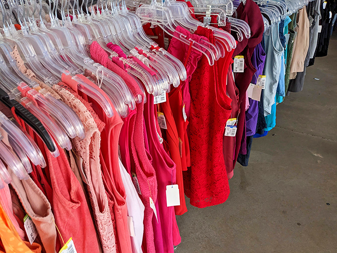 The color-coded clothing racks: like a rainbow of fashion possibilities where coral and crimson create a thrifter's sunset.