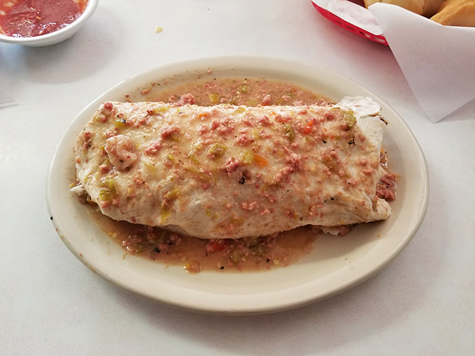 This burrito isn't just wrapped – it's embraced by a flour tortilla and baptized in a sauce that's been perfected over decades of culinary wisdom.