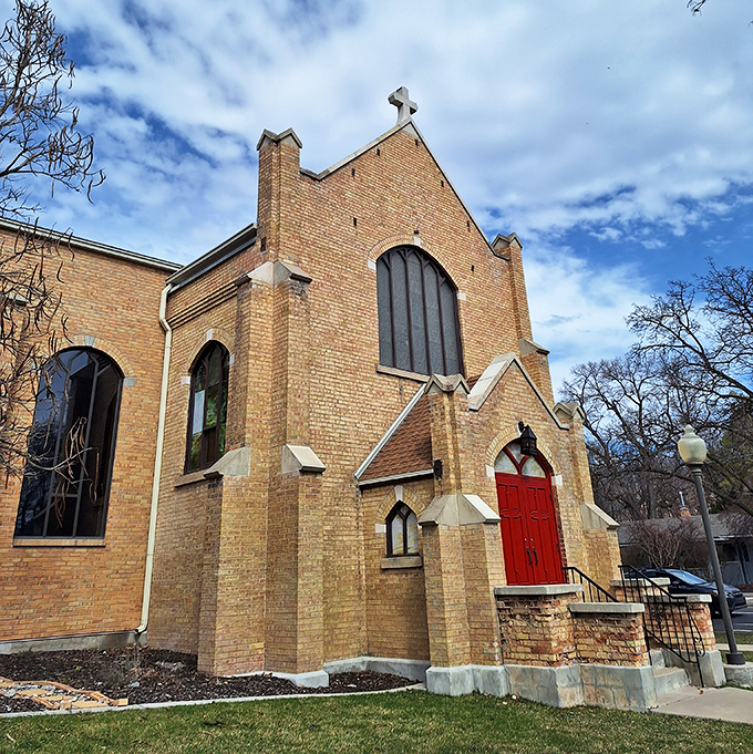 St. John's Episcopal Church welcomes with its warm brick exterior and vibrant red door, a spiritual haven where architectural beauty meets community connection.
