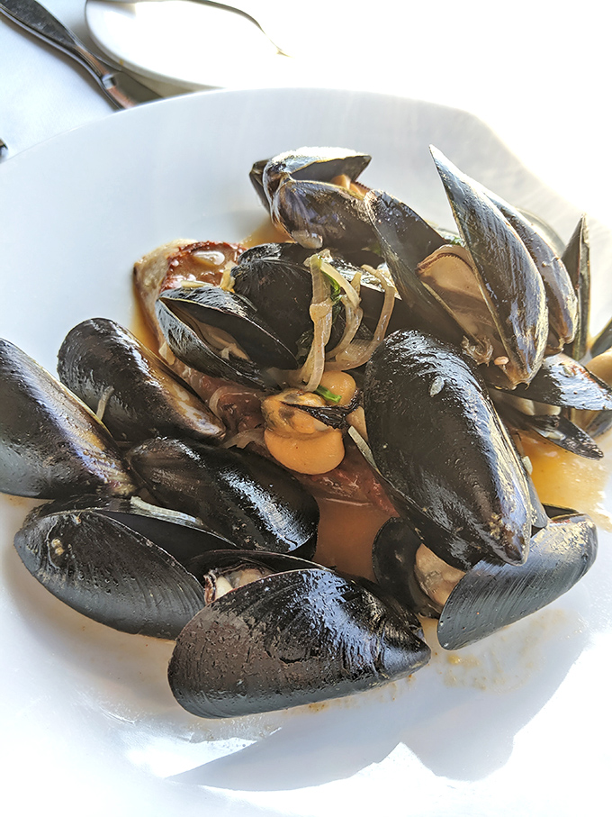 These glistening mussels have opened up to tell their delicious secrets, bathed in a broth you'll want to sip like fine champagne.