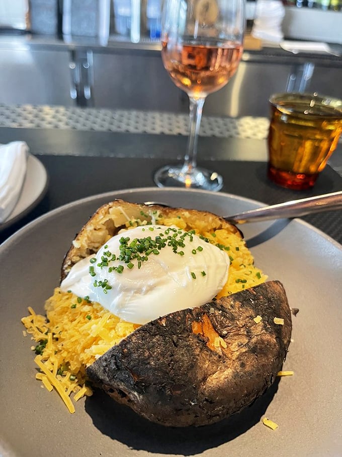 A baked potato living its best life&mdash;stuffed, topped with a cloud of sour cream, and showered with chives and cheese.