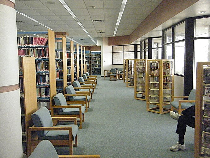 Inside the library, knowledge waits patiently in rows while readers find their perfect afternoon escape.