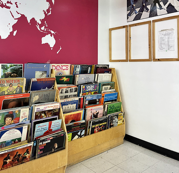 Vinyl heaven against a crimson world map backdrop. Dig through these treasures and you might find the soundtrack to your youth.