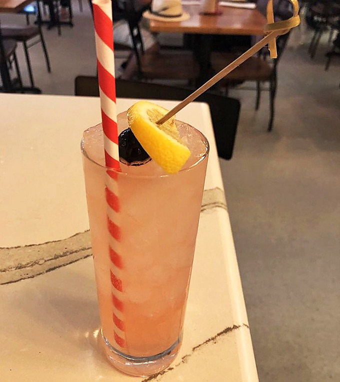 A cocktail that looks like Florida sunset in a glass, complete with that paper straw that will surrender halfway through your drink.