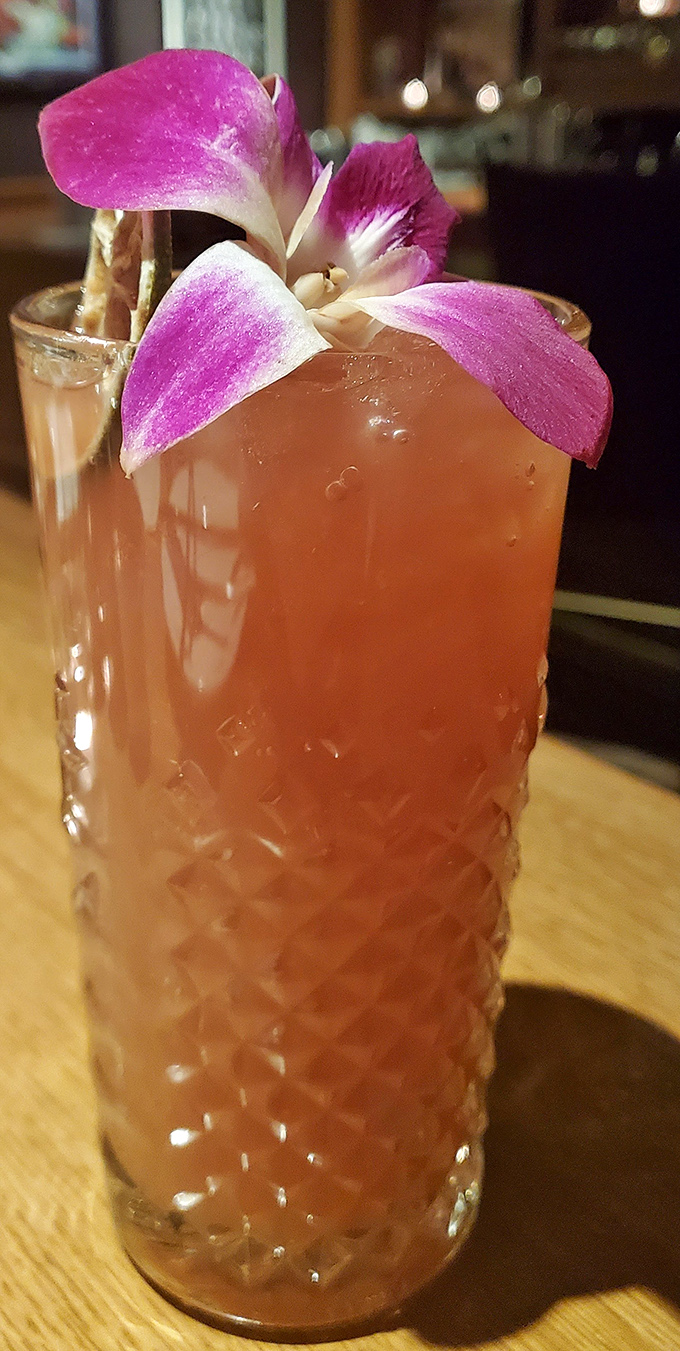 That orchid-topped cocktail arrives looking like it just stepped off Bourbon Street, minus the hangover regret.