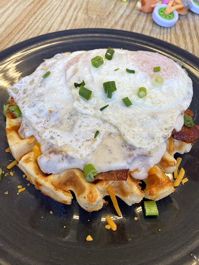 The waffle serves as both plate and canvas, topped with eggs and green onions&mdash;proof that breakfast can be both art and science.