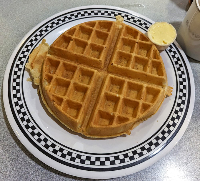 A perfectly golden waffle with a side of butter &ndash; the crispy exterior giving way to fluffy interior is breakfast engineering at its finest.