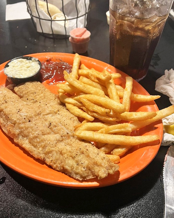 That golden-battered walleye on the bright orange plate isn't just dinner &ndash; it's a North Dakota tradition served with crispy fries and homemade tartar.