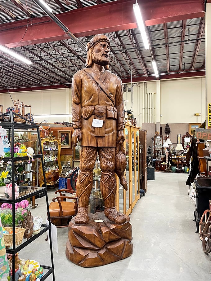 This wooden frontier figure stands guard over vintage treasures like a silent sentinel from America's pioneering past.