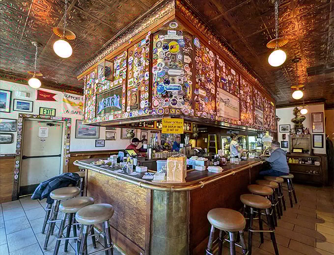 The legendary bar with its famous cheese block (visible on the counter!) and walls covered in patches and stickers&mdash;each one a story waiting to be told.