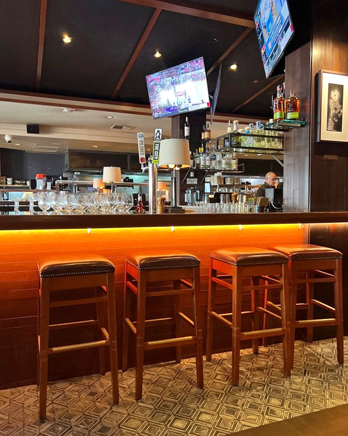 The bar area glows with amber warmth, promising expertly crafted cocktails and the kind of service that remembers your name and your usual.
