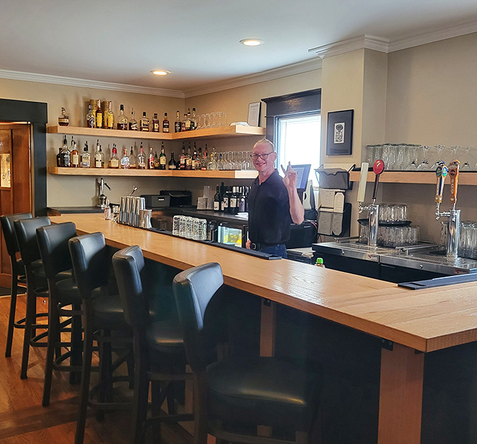 The bar area balances rustic charm with upscale polish, where bottles stand like soldiers ready to enhance your dining experience. A liquid library of possibilities.