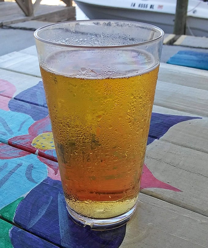 A cold beer sweating almost as much as you were before that first refreshing sip. The colorful table beneath promises you're exactly where you should be.