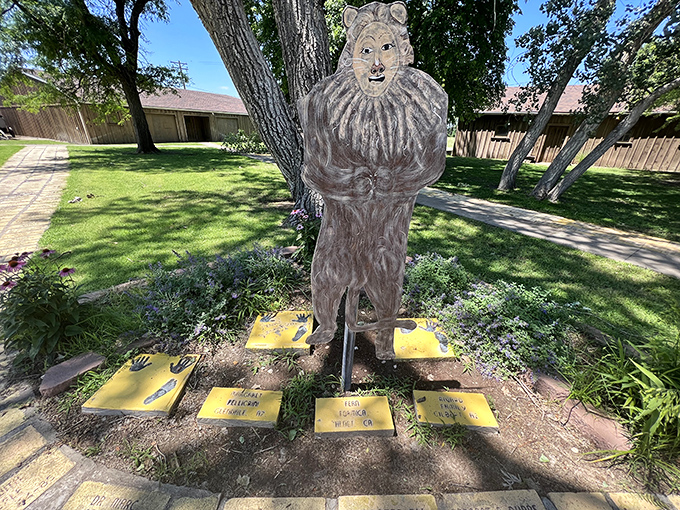 "If I only had the nerve..." The Cowardly Lion stands guard over commemorative bricks, looking braver than he gives himself credit for.