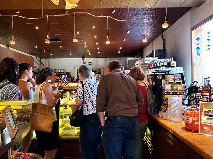 The line of customers stands transfixed by the display case, experiencing that universal moment of sweet indecision we all know too well.
