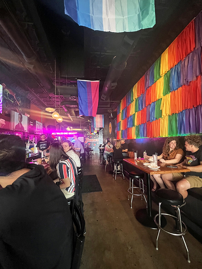 The colorful wall of rainbow streamers isn't just decoration; it's a statement that everyone belongs in this slice of Columbus heaven.
