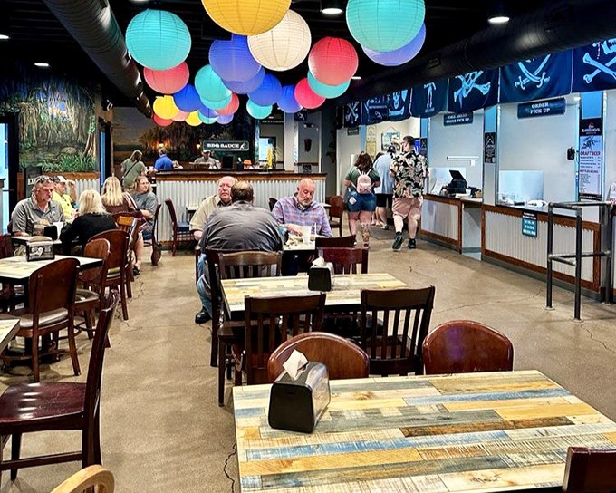 The dining room buzzes with anticipation as patrons gather under those cheerful lanterns, united in the universal language of "pass the napkins, please."