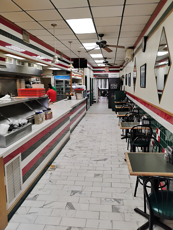 The dining area whispers, "We put our energy into the food, not the furniture." Those red and green tiles have witnessed countless pizza epiphanies.